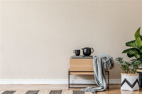 세련된 Commode 열대 식물 책 차 주전자와 우아한 액세서리와 스칸디나비아 아파트에서 거실의 인테리어 디자인 현대적인 홈 장식 템플릿 공간을 복사합니다 베이지 색