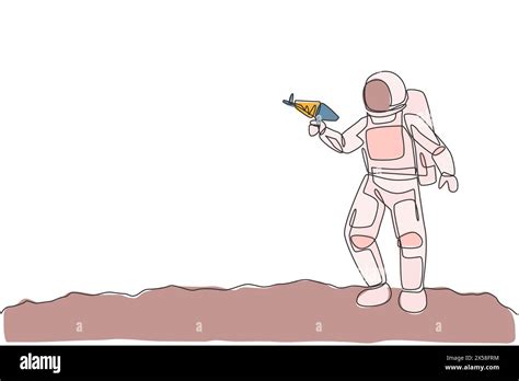 Single Continuous Line Drawing Of Young Astronaut Holding Space Laser Gun And Pose To Shot In