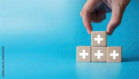 Value Add Concept Hand Place Wooden Cube With Plus Sign On Light Blue