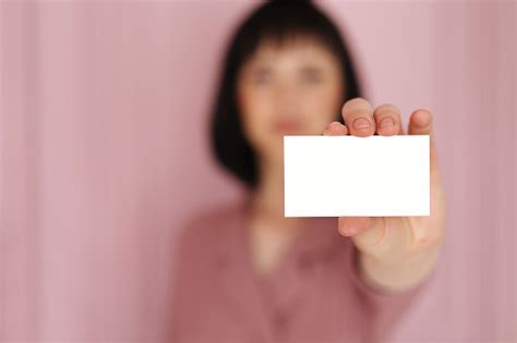 빈 명함을 보여주고 건네는 사업가 하얀 비즈니스 방문 카드 선물 티켓 패스를 들고 손이 흐릿한 파란색 배경에 클로즈업합니다 공간을 복사합니다 프리젠테이션 연설에 대한 스톡