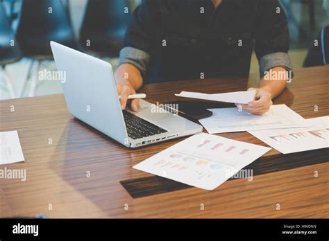 People Working With Document And Laptop Computer In Office Workplace