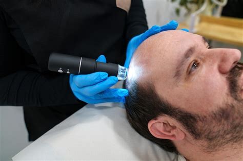 Premium Photo Professional Performing Scalp Treatment On A Male Patient