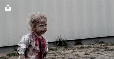 분홍색과 흰색 꽃 드레스를 입은 소녀는 낮 동안 푸른 잔디밭에 서 있습니다 사진 Unsplash의 무료 좀비 이미지