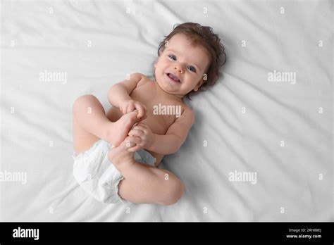 Cute Baby In Diaper Lying On Bed Top View Stock Photo Alamy