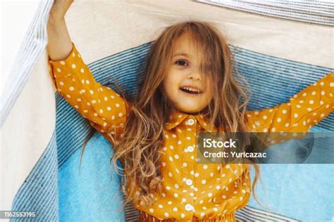 담요 아래 재생 행복 한 작은 금발 소녀의 초상화 광범위 하 게 미소 여름 날을 즐기고 공원에서 가족과 함께 휴가 를 보내는 동안 사랑스러운 아이 어린 시절 개념 가족에