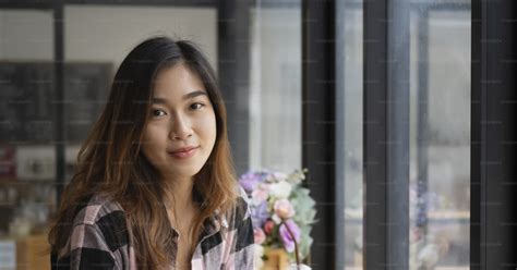 젊은 디자이너가 컴퓨터 테이블을 들고 커피숍의 창문 근처에 앉아 카메라를 향해 웃고 있는 초상화 사진 Unsplash의 앉아 이미지