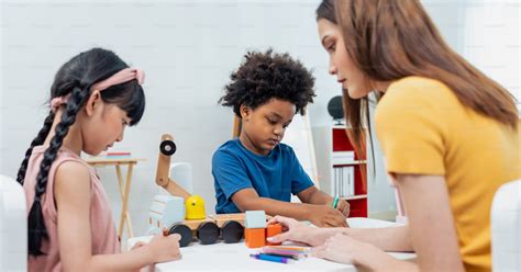 아시아의 아름다운 젊은 여성 교사가 학교에서 아이에게 수업을 가르치고 있다 매력적인 여성 강사 마스터가 유치원 교실에서 재미있는 활동으로 어린이 학생을 설명하고 교육합니다