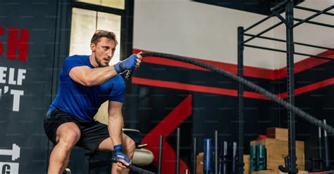 백인 활동적인 잘 생긴 스포츠맨은 피트니스 체육관 클럽에서 운동하고 있습니다 피트니스 경기장에서 건강 관리 라이프 스타일을 위해 체중을 줄이고 근육을 유지하기 위해 배틀