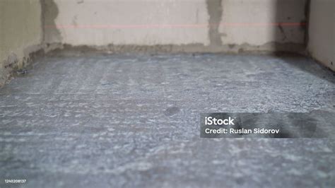 롤러를 들고 있는 남자의 손은 콘크리트 바닥에 프라이머를 놓는다 콘크리트 바닥용 프라이머 0명에 대한 스톡 사진 및 기타 이미지