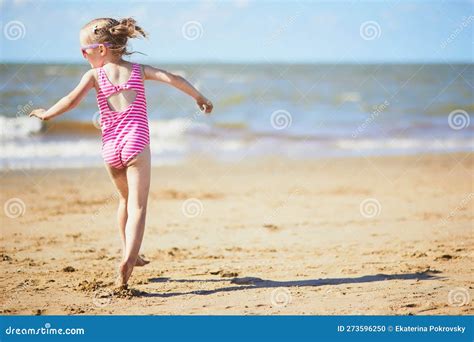 Preschooler Girl Having Fun On The Sand Beach At Sea Coast In Noordwijk