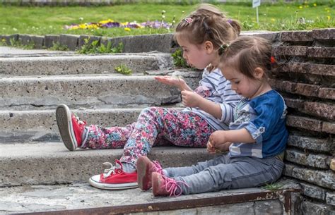 Deux Petites Filles Assises Sur Les Marches à L extérieur Le Concept D