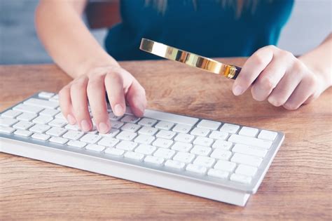 Premium Photo Woman Looking At The Keyboard With A Magnifying Glass