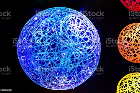 검은 공간에 플라스틱 섬유의 질감과 여러 가지 빛깔의 파란색 빨간색 노란색 오렌지 공의 꼰 모양과 추상 네온 미래 마법 빛나는 예술 Led 배경 0명에 대한 스톡 사진 및