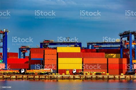 창고에 바다 근처 항구에 수입 및 수출 지역의 컨테이너 창고에있는 긴 트럭은 차량에화물을 적재하기위한 갠트리 컨테이너 크레인이