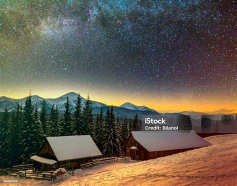오래 된 목조 주택 오두막 및 축 사 산 골짜기 가문비나무 숲 깊은 눈에 장작 더미 어두운 밤하늘에은 하 수 우 디 언덕 우주