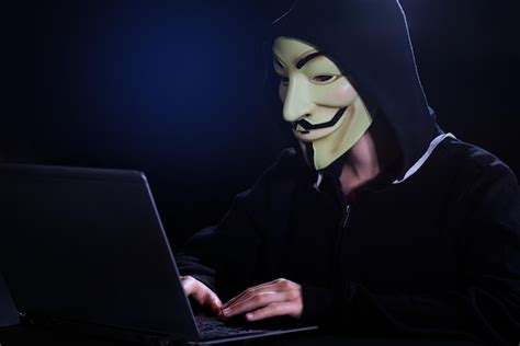 Premium Photo Computer Hacker Wearing Mask Using Laptop Against Black Background