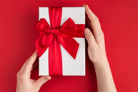 깜짝 준비 개념 빨간 리본이 빨간색 배경에 고립 된 흰색 선물 상자를 들고있는 여성 손의 오버 헤드 뷰 사진 상단 12월에 대한 스톡 사진 및 기타 이미지 Istock