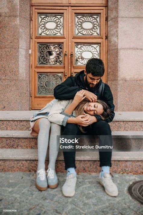 남자가 그녀의 머리와 함께 재생 하는 동안 여자는 닫힌 눈으로 웃는 그녀의 남자 친구의 무릎에 그녀의 머리를 기대 하는 동안