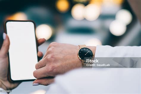 거리의 클래식 손목 시계에서 스마트 폰 체크 시간을 가진 얼굴이없는 여성을 자르십시오 Brand Name Smart Phone에 대한 스톡 사진 및 기타 이미지