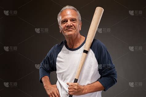 一个年长男子的肖像与棒球棒摆姿势
