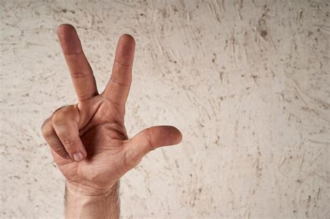 Premium Photo Mans Hand With Three Fingers Raised