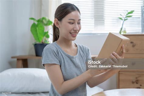 아시아 여성이 흥분하여 소포 상자를 열고 그녀는 소포 상자에있는 물건을보고 행복한 표정을 보여주었습니다 가정 생활에 대한 스톡 사진 및 기타 이미지 Istock