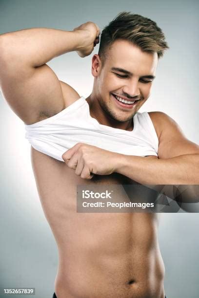 회색 배경에 대한 자신의 탱크 탑을 복용 잘 생긴 젊은 남자의 스튜디오 샷 남자에 대한 스톡 사진 및 기타 이미지 남자 셔츠 옷 벗기 Istock