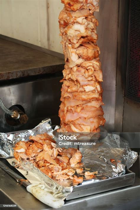수직 회전 로티세리에서 조리 한 고기로 만든 금속 화격자에 터키 스타일의 도너 케밥의 이미지 요리 요소 옆에 거꾸로 콘모양으로 쌓인 양념 고기 조리된 고기의 쉐이식으로 썰어