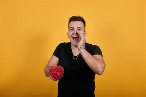 잘 생긴 젊은 남자 미소 손바닥으로 얼굴을 덮고 빨간 상자를 유지 갈색 머리에 대한 스톡 사진 및 기타 이미지 갈색 머리