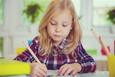 premium photo girl drawing on book while sitting on table at home