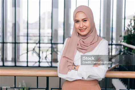 젊은 행복하고 성공적인 동남 아시아 이슬람 비즈니스 여성 팔을 교차 하는 비즈니스 기업 건물 설정 카메라에 보이는 여자에 대한