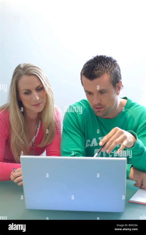 Couple Looking At Notebook Computer Man Pointing To Screen Stock Photo Alamy