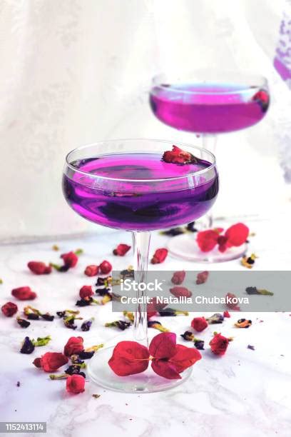 태국 아시안 퍼플 안 차 칵테일 안경에 드라이 로즈 싹과 블루 티 찻 잎 및 녹색 바 질 잎 건강 한 유기농 해독 아시아 초본 차 Clitoria 나비 완두콩 대리석 배경