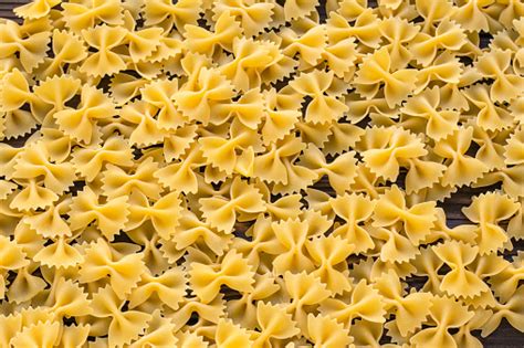 짧은 파스타 더미 활 모양 멀리 떨어지는 질감 노란색 원시 마카로니의 힙 음식 배경입니다 레시피의 성분 건강한 식생활에 대한 스톡 사진 및 기타 이미지 Istock