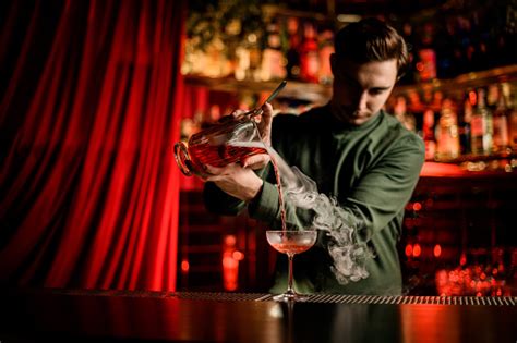 바 카운터에서 밝은 김이 나는 칵테일을 유리에 붓는 젊은 바텐더 강철에 대한 스톡 사진 및 기타 이미지 강철 결정체 남성 Istock