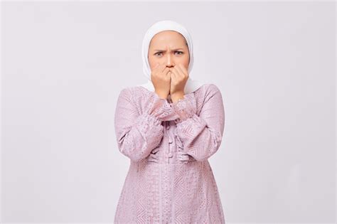 히잡과 보라색 드레스를 입은 두려운 아름다운 젊은 아시아 무슬림 여성의 초상화는 흰색 스튜디오 배경에 고립된 입에 손을 대고 스트레스를 받고 긴장한 것처럼 보인다 Eid