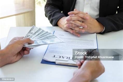 불법 부정직 뇌물 수수 및 부패 개념 사업가는 뇌물 사기에 대한 부패 사기에서 거래 계약을 성공하기 위해 파트너의 봉투에 뇌물을 주는 계약서에 대한 스톡 사진 및 기타
