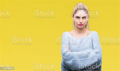 젊은 아름 다운 금발 및 파란 눈 여성 고립 된 배경 회의론과 긴장에 겨울 스웨터를 입고 교차 팔과 얼굴에 표현을 거부 부정적인 사람 감정에 대한 스톡 사진 및 기타 이미지