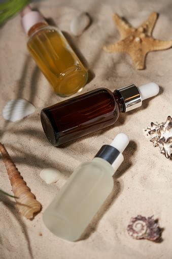 모래 배경에 세 개의 여름 자외선 차단제 에센스와 조개껍데기와 바다별이 있습니다 메이크업 화장품에 대한 스톡 사진 및 기타 이미지 메이크업 화장품 해변 개념 Istock