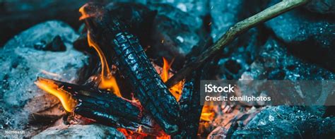 불에 타버린 생생한 연기가 나는 장작이 클로즈업되었습니다 모닥불의 주황색 불꽃이 있는 분위기 있는 따뜻한 배경 모닥불의 상상할 수없는 풀 프레임 이미지 아름다운 불에