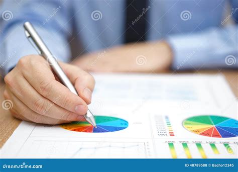 Businessman Is Analyzing Business Report With Charts And Diagram Stock