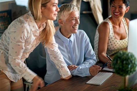 사무실에서 책상에 앉아 컴퓨터 화면을 함께 보고 있는 쾌활한 여성 동료들 비즈니스 사무실 직업 3 명에 대한 스톡 사진 및 기타 이미지 Istock