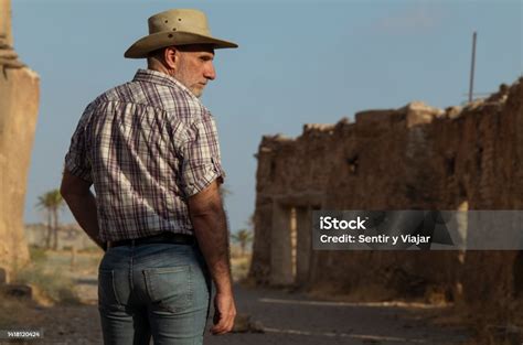 버려진 건물에 대한 카우보이 모자와 셔츠를 입은 성인 남성의 뒷모습 카우보이에 대한 스톡 사진 및 기타 이미지 카우보이 개척시대의 서부 건축 Istock