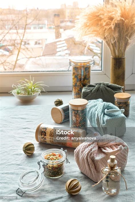 폐기물 선물 음식 재료 항아리 차 잎 수건 후로시키 스타일로 포장 된 상자 겹겹이 겹쳐진 콩과 시리얼을 곁들인 유리 항아리 창 옆 섬유로 덮인 테이블에 지속 가능한 선물