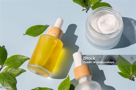 화장품 용기 모형 브랜딩 및 패키징 프레젠테이션을 위한 트렌디한 배경 내츄럴 스킨케어 뷰티 제품 컨셉 혈청 녹색 잎과 하드 섀도우가 있는 에센스와 스프레이 뷰티 세트 0명에