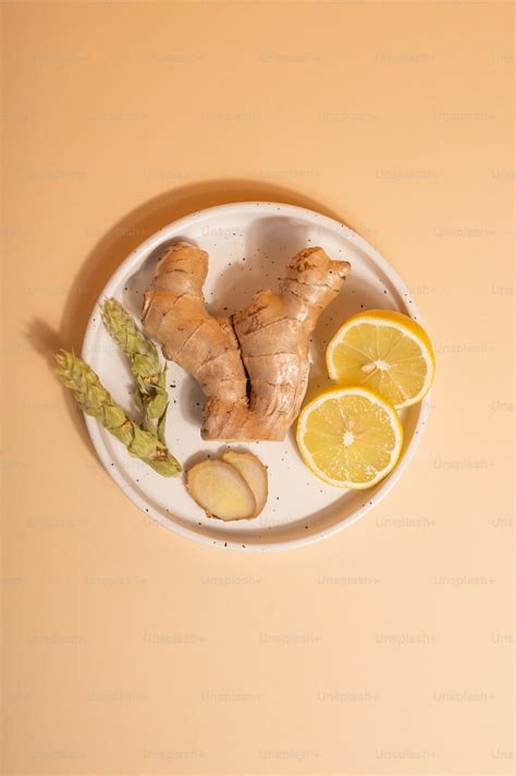 얇게 썬 레몬과 생강을 얹은 흰색 접시 사진 Unsplash의 레몬 이미지