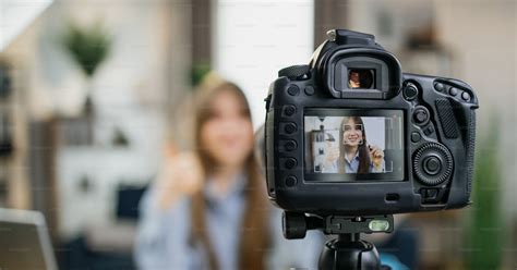 테이블에 앉아 새로운 화장품에 대한 비디오 리뷰를 하는 예쁜 여성 인플루언서 집에서 일하기 위해 현대 카메라를 사용하는 젊은 여성 사진 Unsplash의 소셜 미디어 이미지