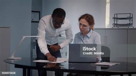 노트북 컴퓨터를 사용하는 다양한 사업가들이 현대 사무실의 책상에서 함께 일하고 있다 연수생에 대한 스톡 사진 및 기타 이미지