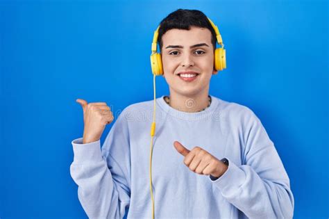 Non Binary Person Listening To Music Using Headphones Pointing To The