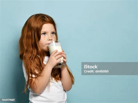 귀여운 빨간 머리 의 아이 소녀는 무료 복사 공간을보고 우유 또는 케피어 요구르트 의 한 잔을 보유하고 건강한 생활방식에 대한